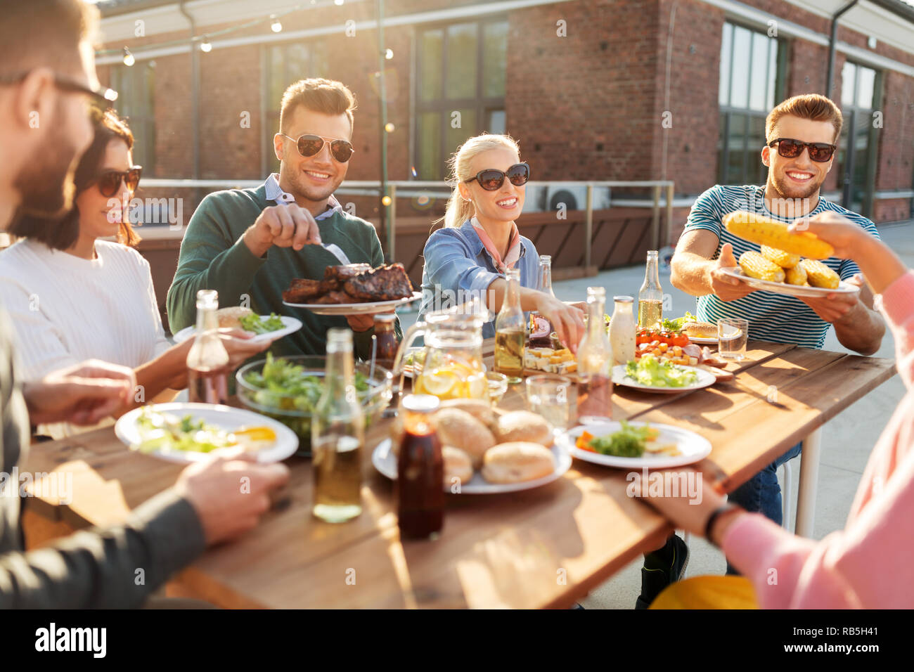 happy friends eating at barbecue party on rooftop Stock Photo - Alamy
