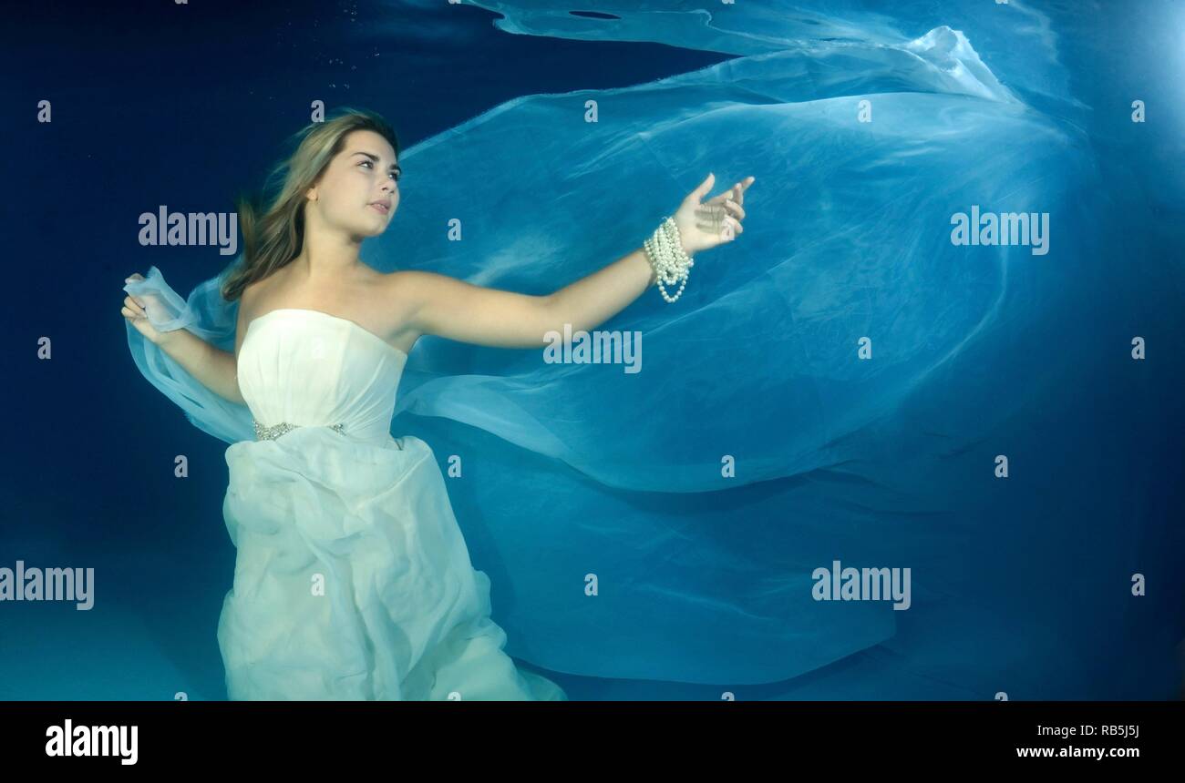 Woman presenting underwater fashion in a pool Stock Photo - Alamy