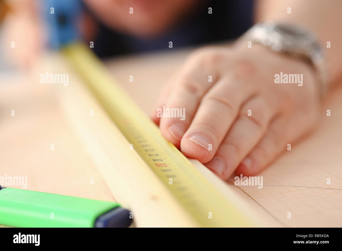 Arms of worker measuring wooden bar Stock Photo - Alamy