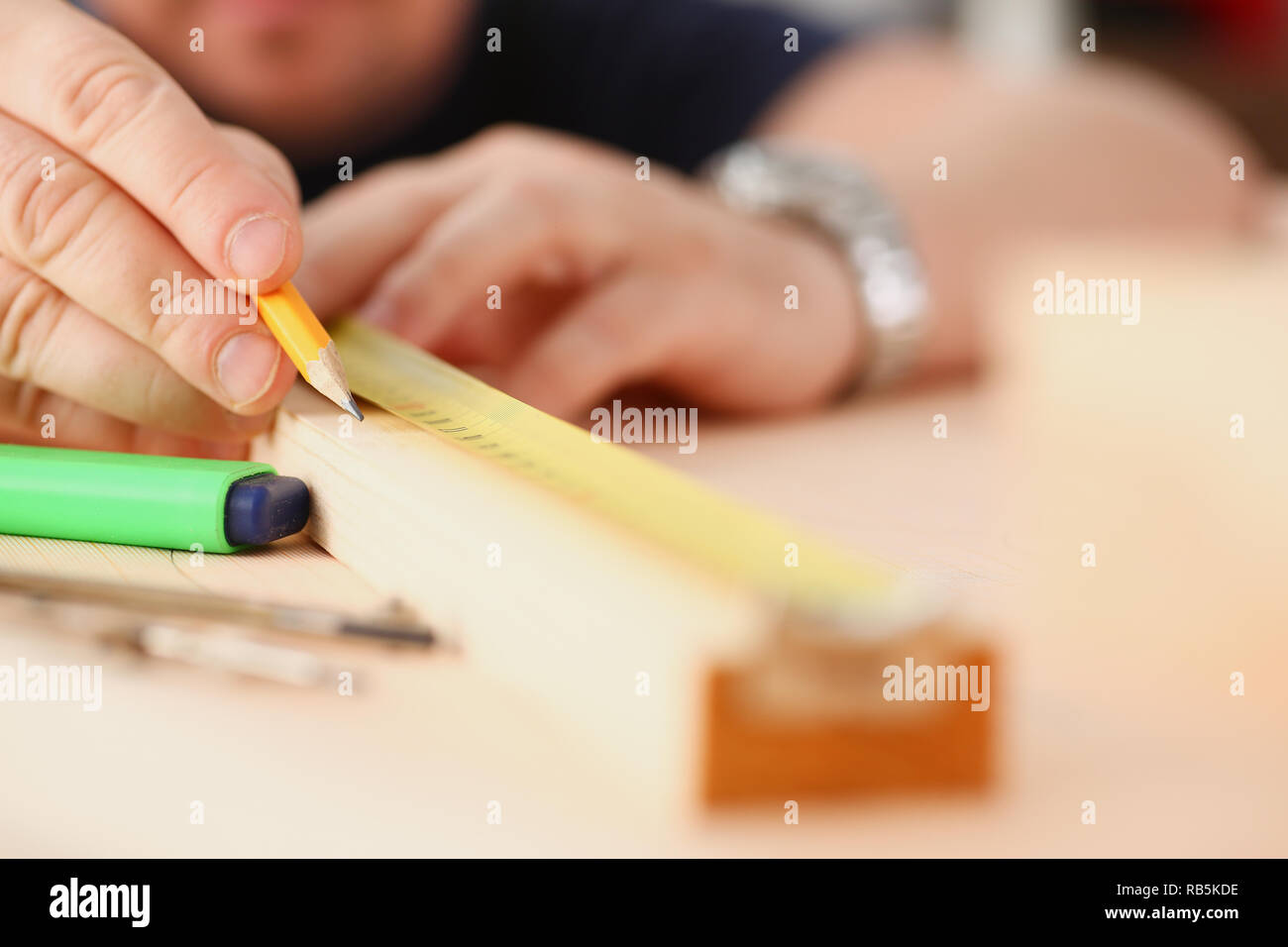 Arms of worker measuring wooden bar Stock Photo - Alamy
