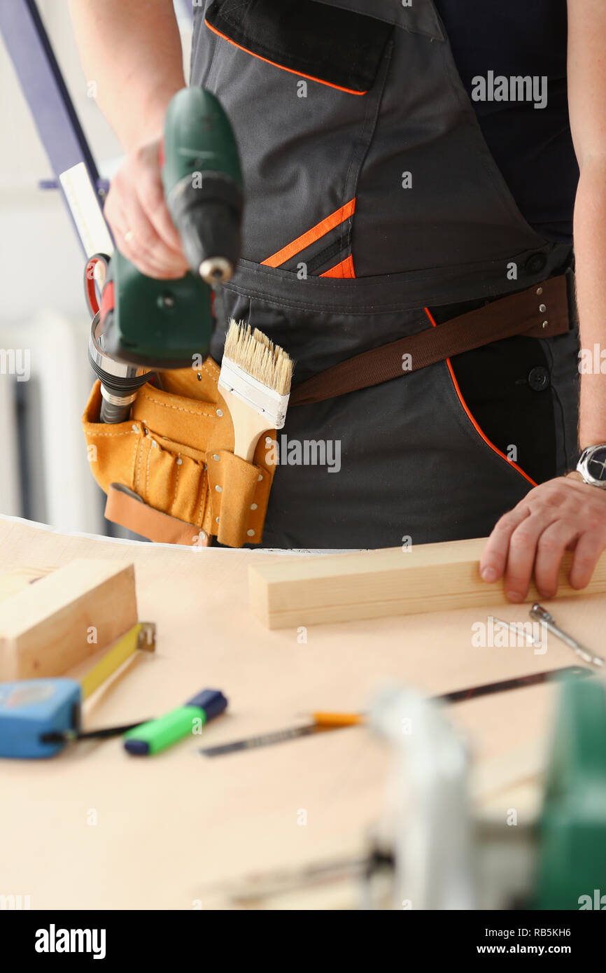 Arms of worker using electric drill Stock Photo - Alamy