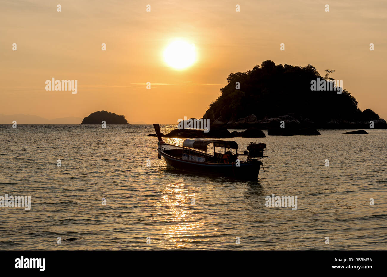 Early morning sunrise over the sea and a fishing boat Stock Photo - Alamy
