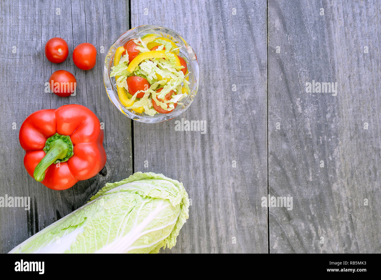 Vegetable salad with fresh vegetables lying separately on a wooden ...