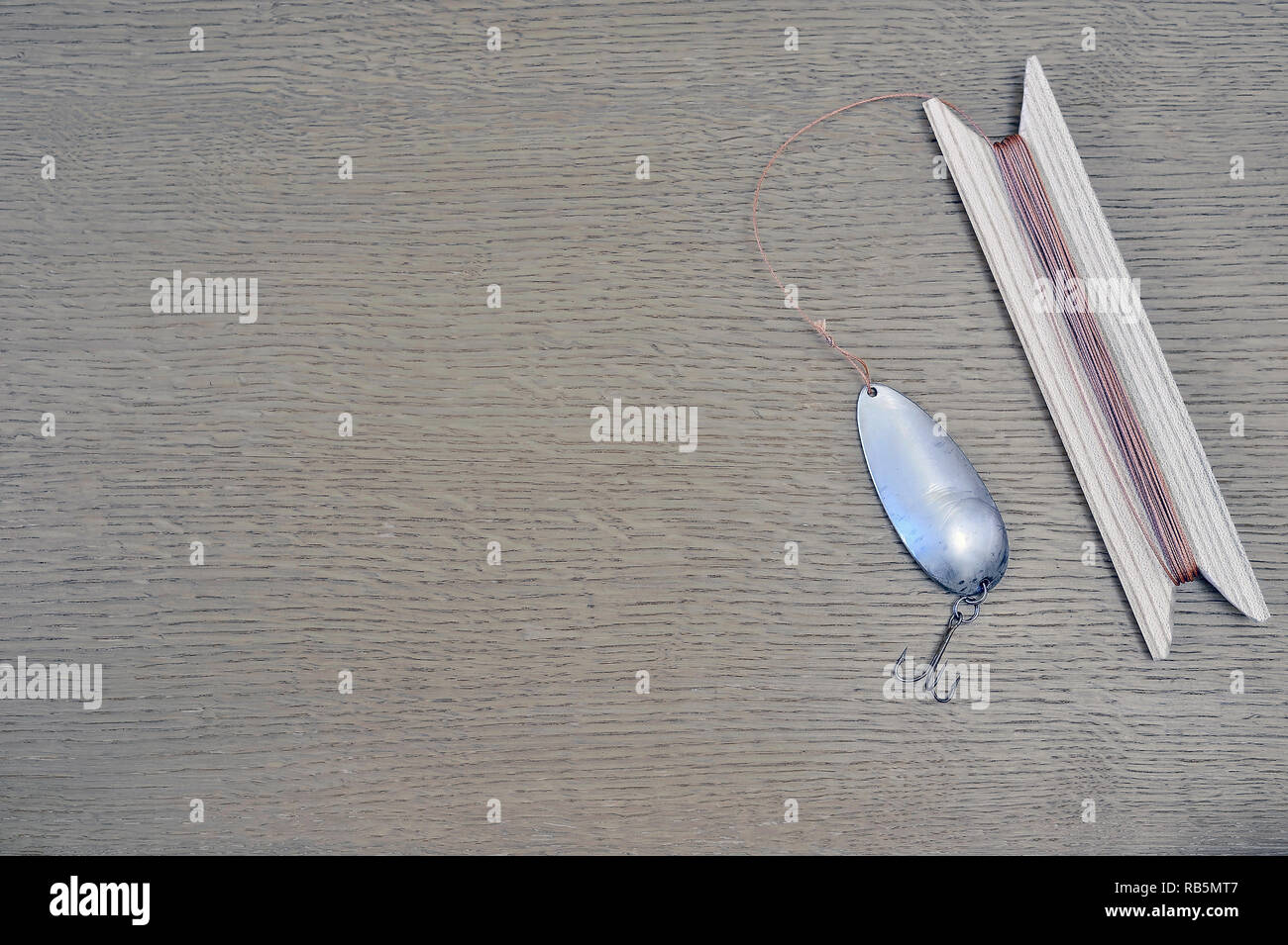 Homemade spoon spinner with a cord tied to it and wound on a wooden ...