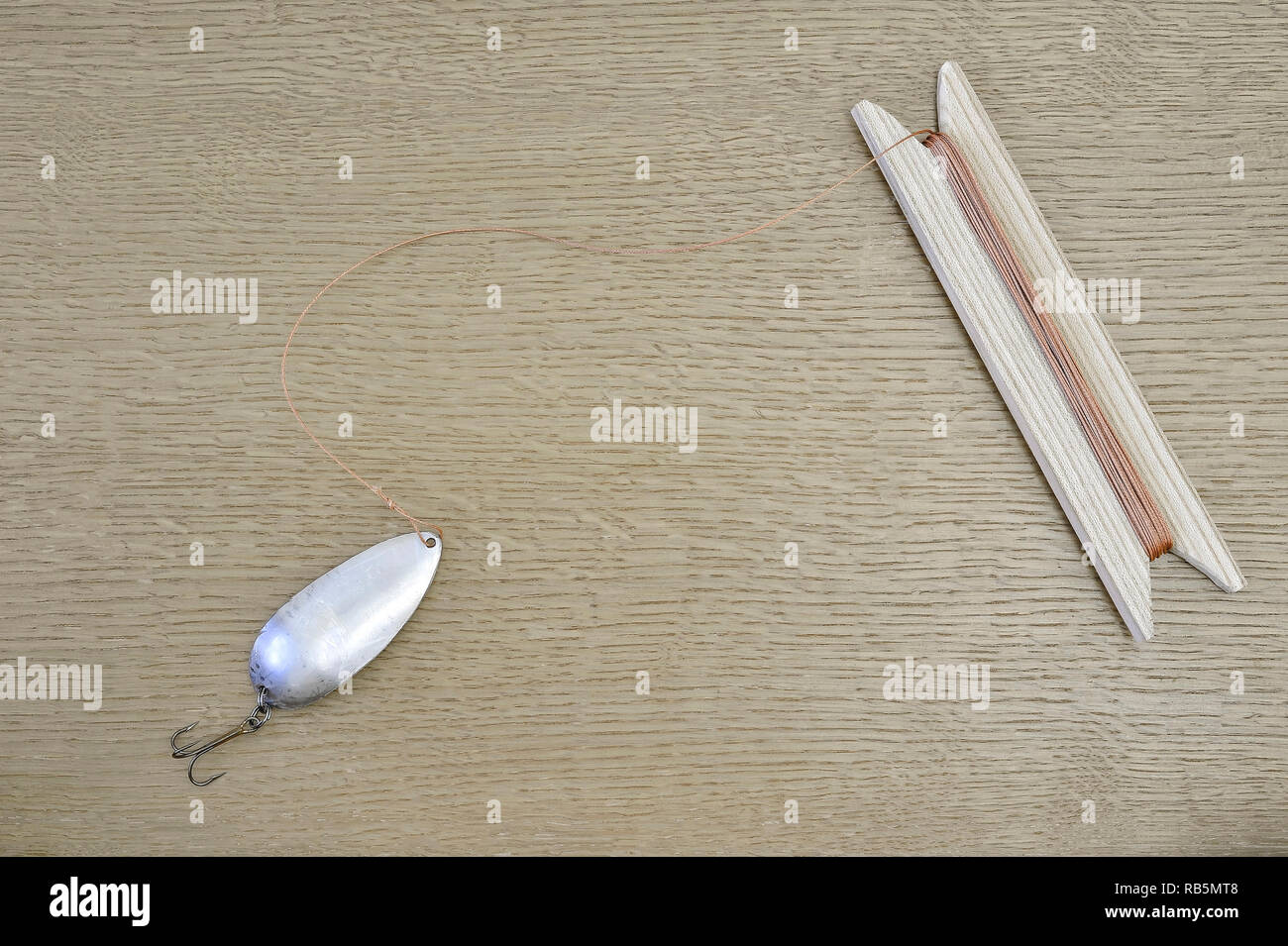 Homemade spoon spinner with a cord tied to it and wound on a wooden ...