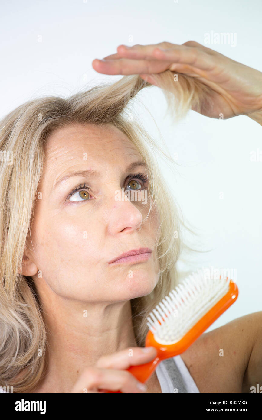 Woman looking at her split ends Stock Photo - Alamy