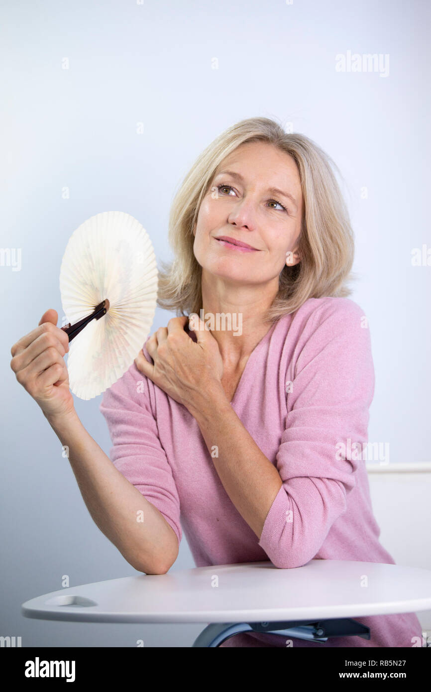 A menopausal woman having a hot flush Stock Photo - Alamy