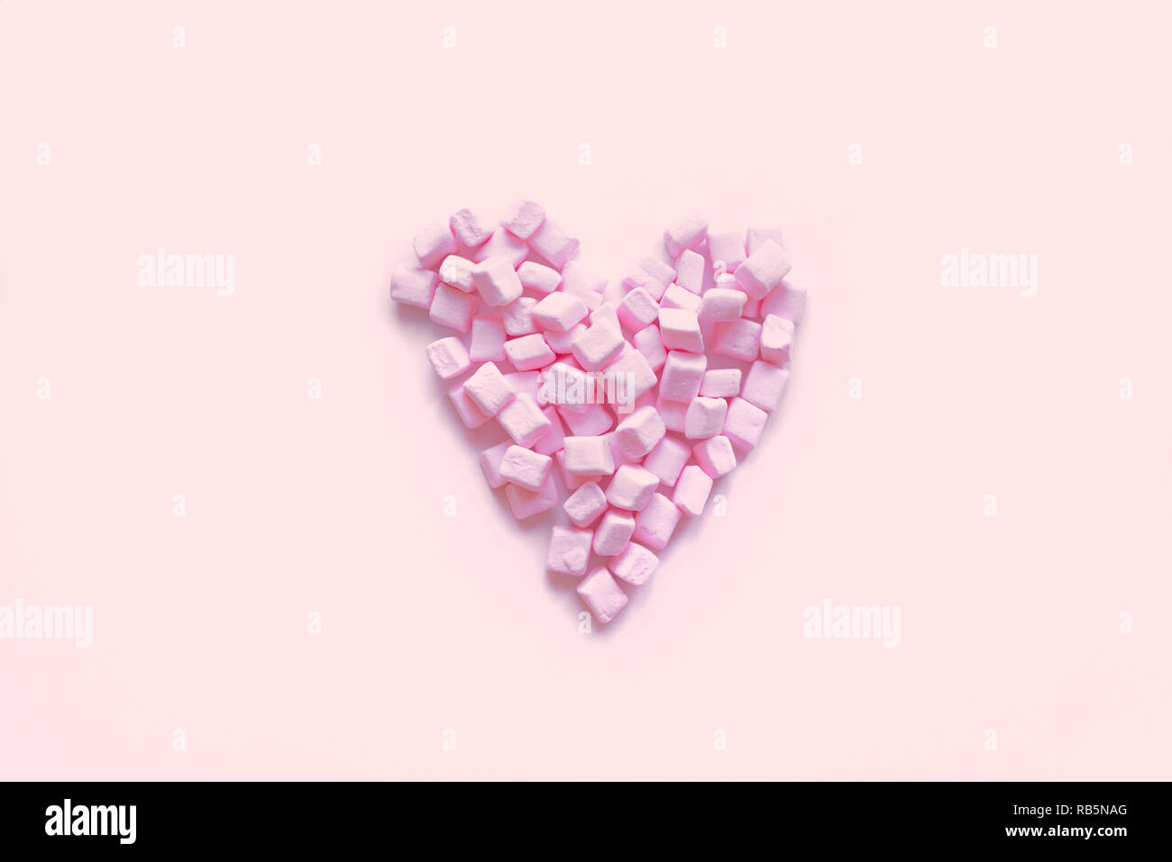 Pink marshmallows in the shape of heart on pink background, copy space ...