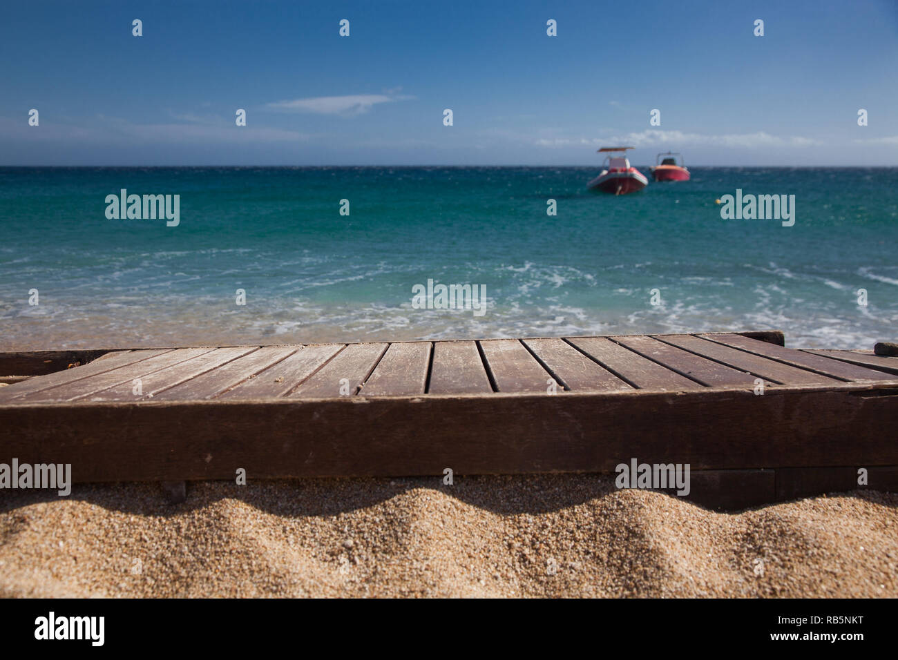 wooden plank in sand and blue sea in the background Stock Photo - Alamy