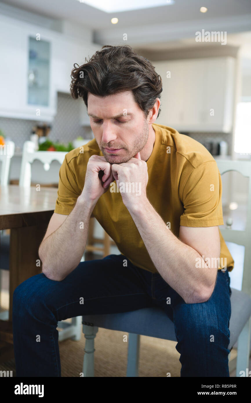 Worried man sitting at home Stock Photo - Alamy