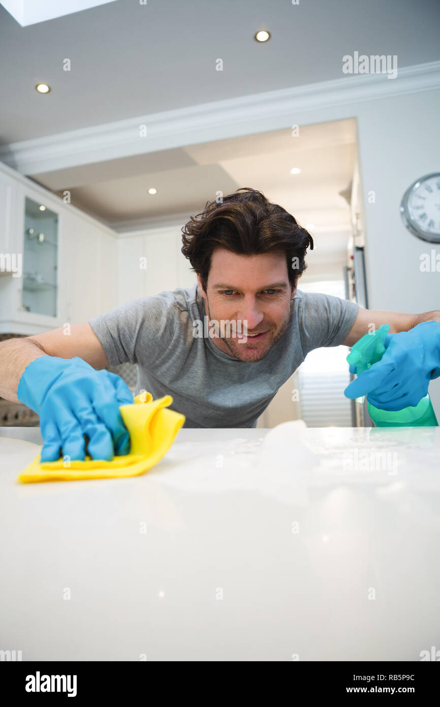 Man cleaning kitchen worktop at home Stock Photo - Alamy