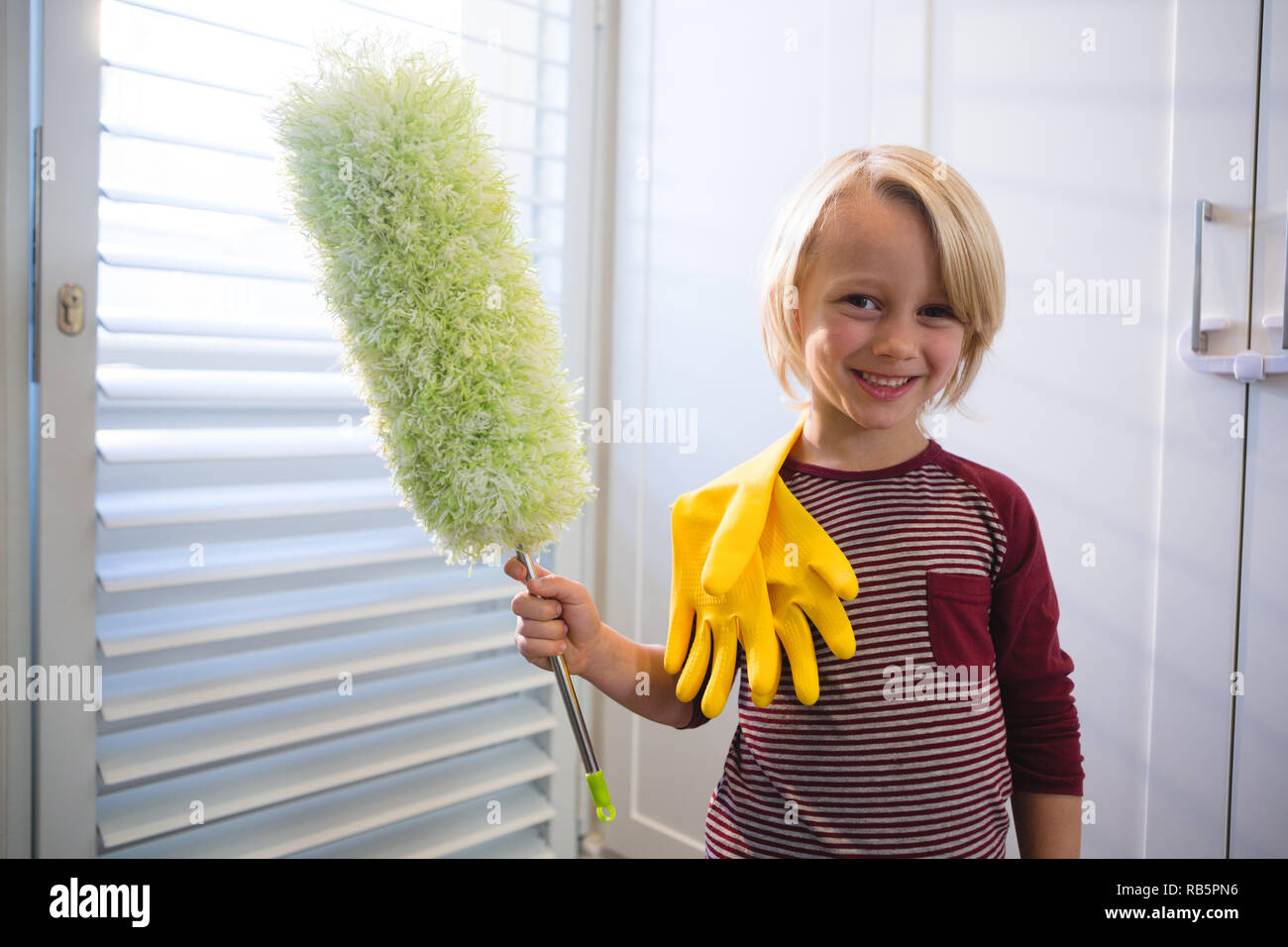 Boy holding a mop at home Stock Photo - Alamy