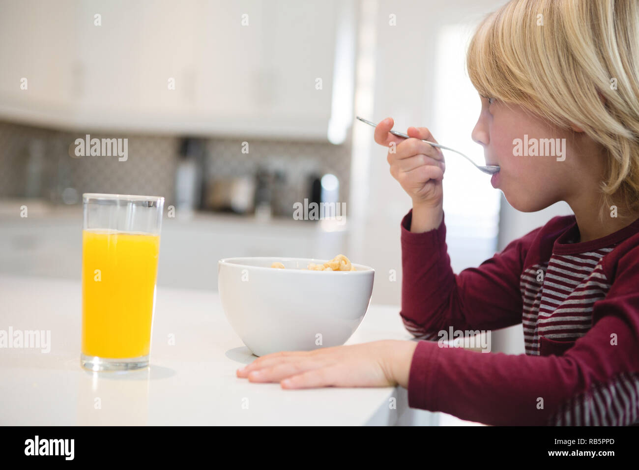 Boy having his breakfast at home Stock Photo - Alamy