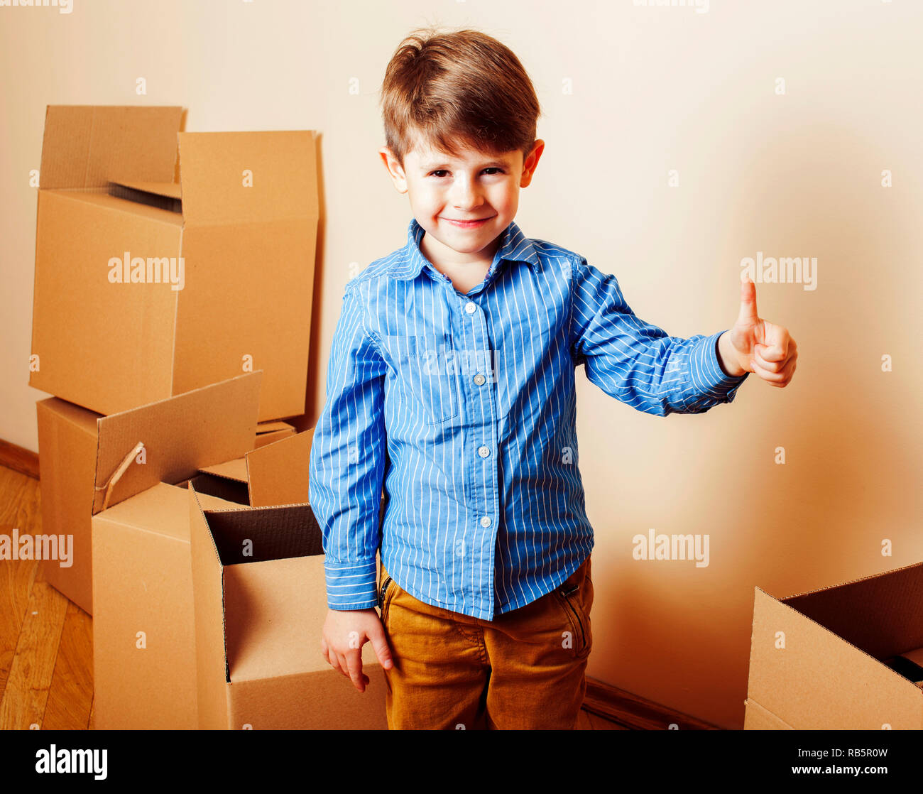 little cute boy in empty room with many boxes, remoove to new ho Stock ...