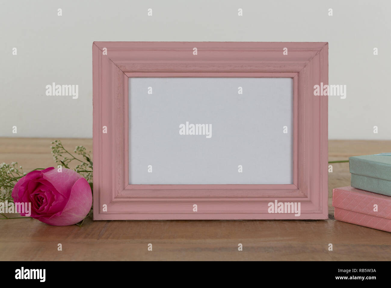 Rose flower, empty photo frame and gift boxes Stock Photo - Alamy