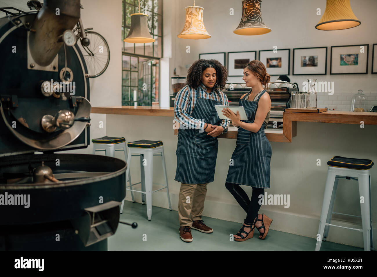 Pretty coffee cafe manager pointing to digital tablet and talking ...