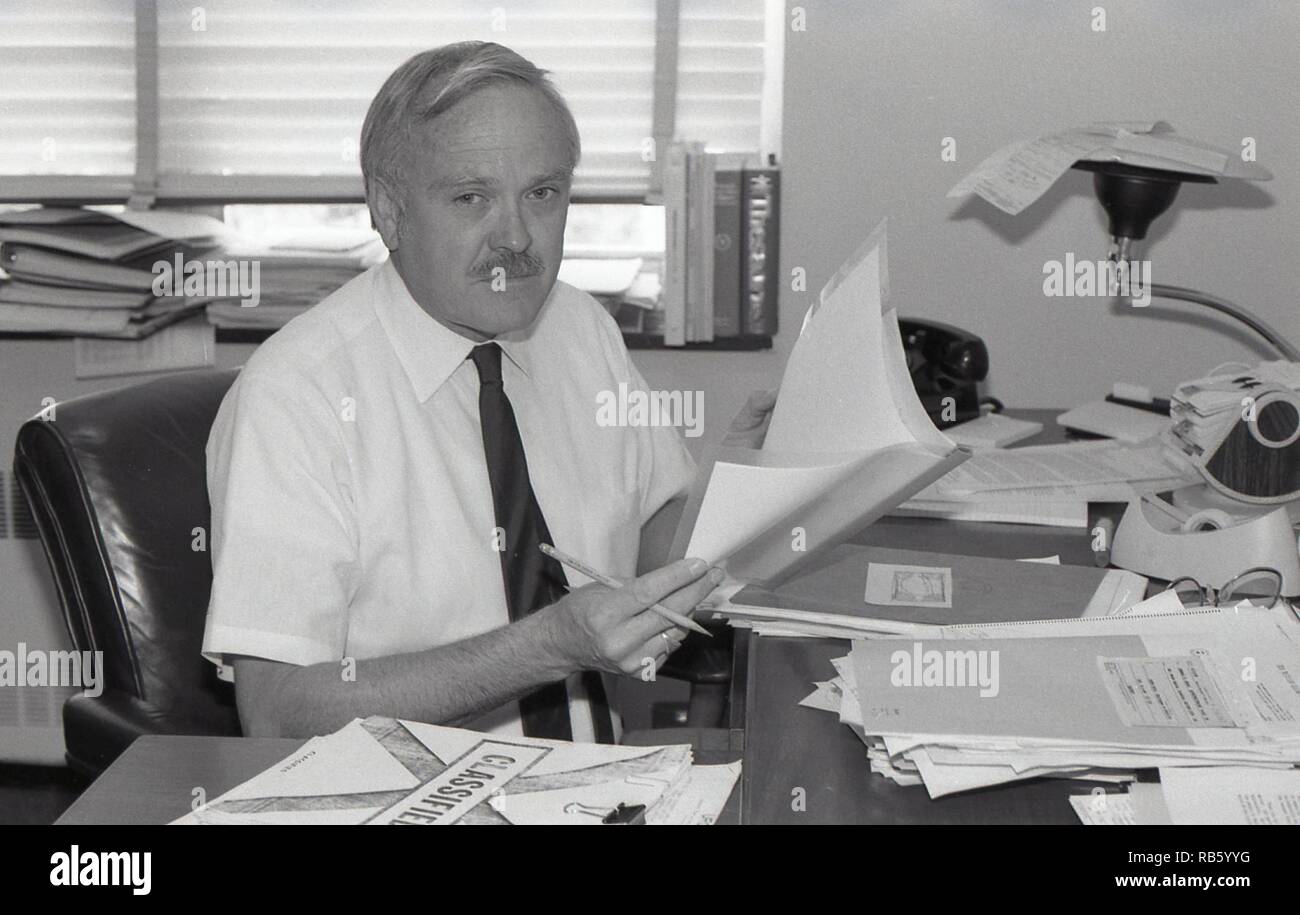 Desks Officer for article - Looking over documents Stock Photo - Alamy
