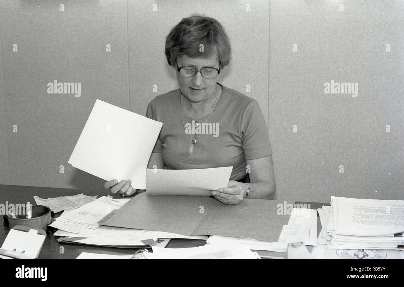 Desks Officer for article - Looking over documents Stock Photo - Alamy