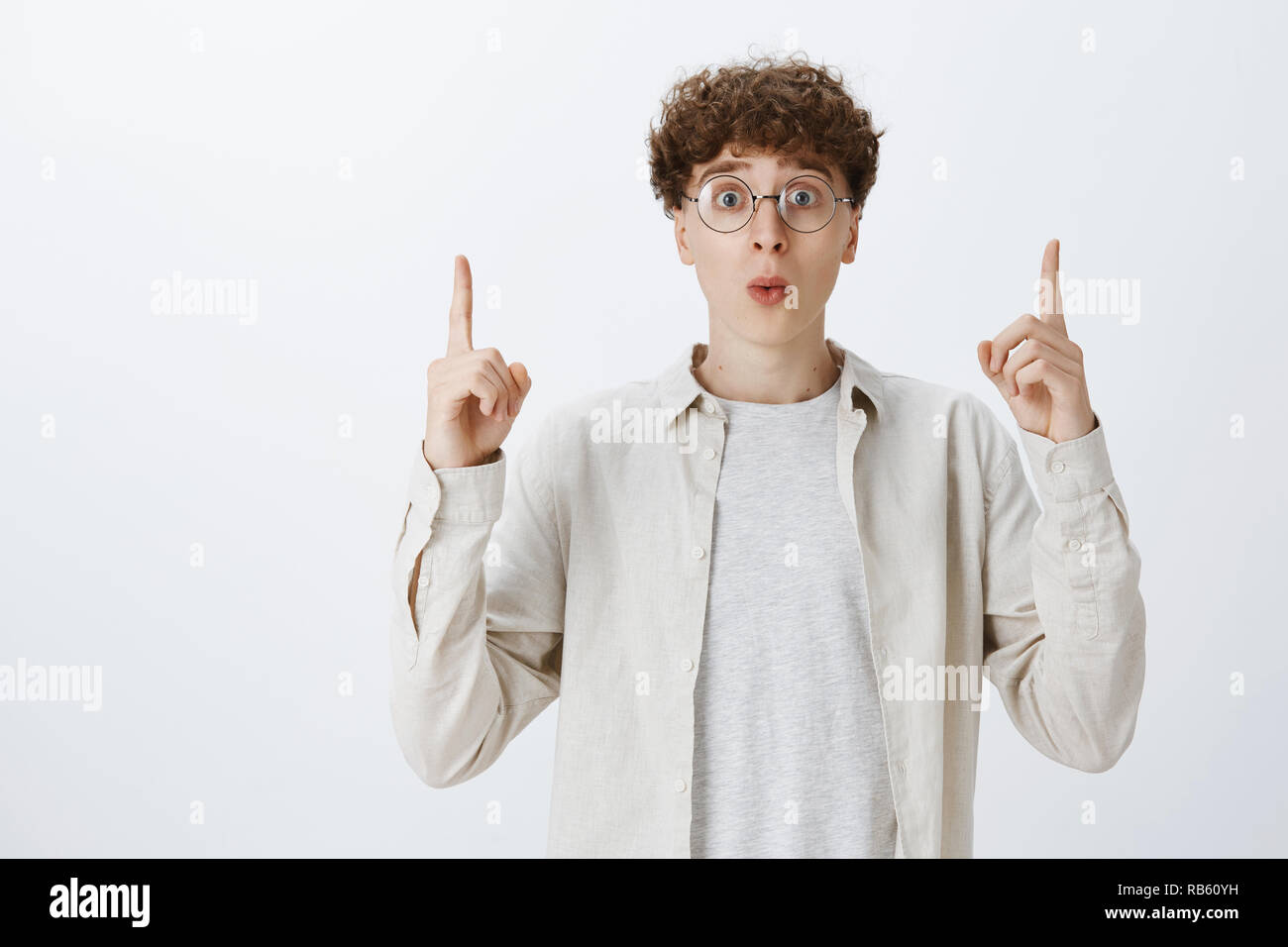 Waist-up shot of timid and insecure amazed guy folding lips in interest ...