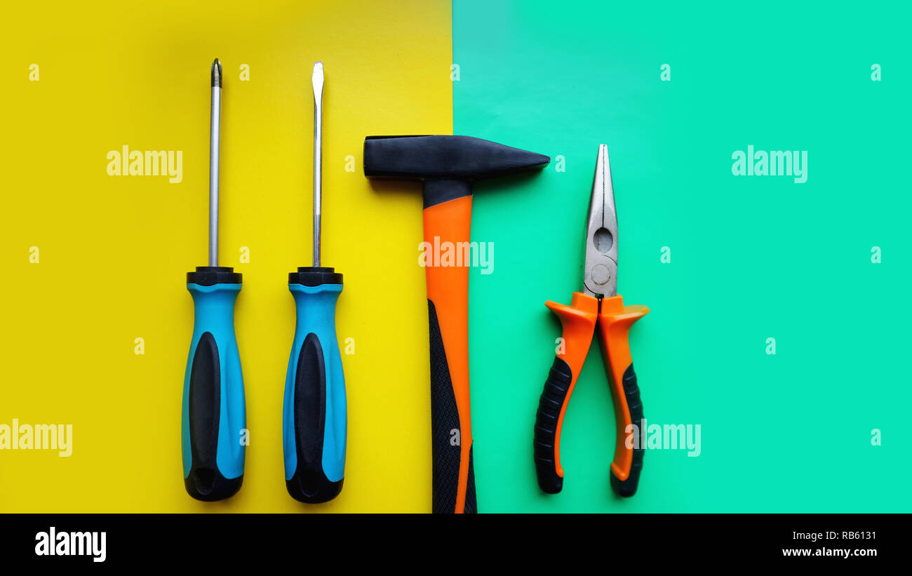 Tools worker, hammer, screwdrivers, pliers on bright yellow and blue ...