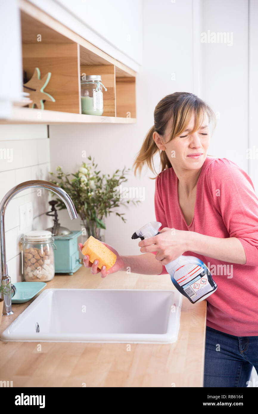 Woman using a conventional cleaning product Stock Photo - Alamy