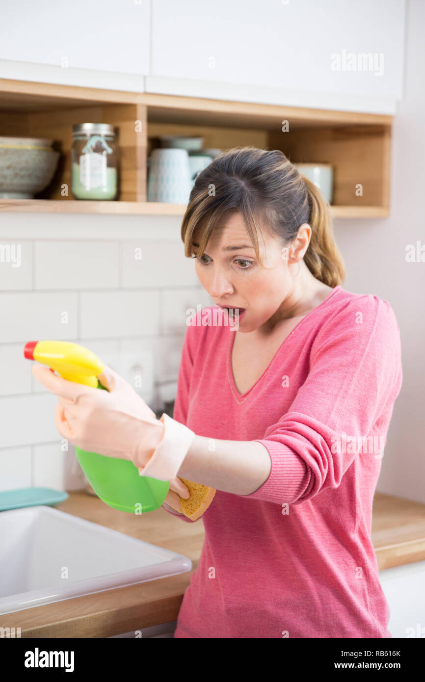 Woman using a conventional cleaning product Stock Photo - Alamy