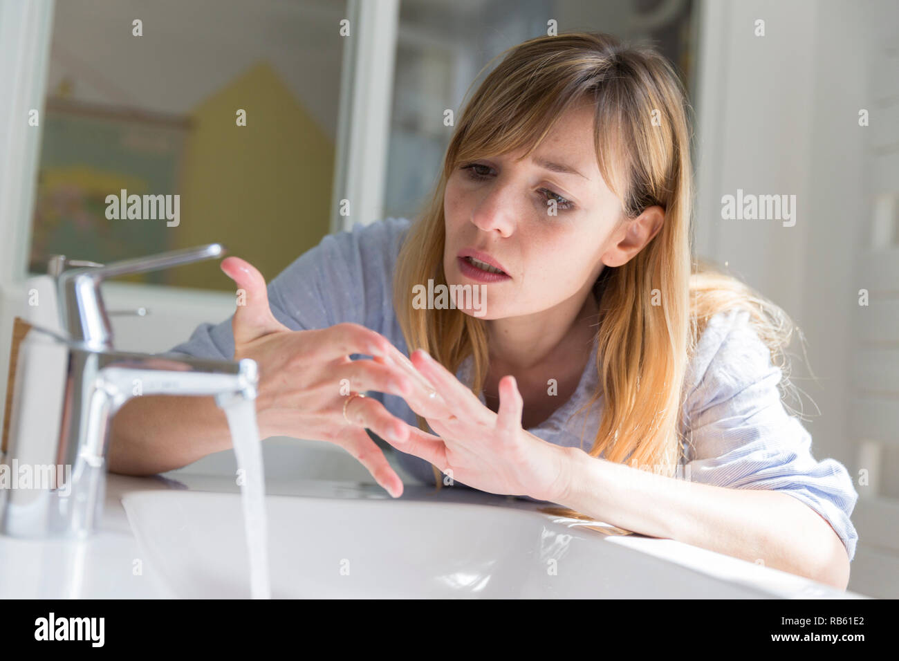 A woman suffering from contamination OCD: obsessive hand washing Stock ...