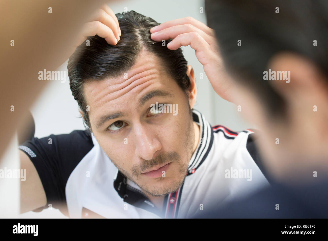Man looking in a mirror Stock Photo - Alamy