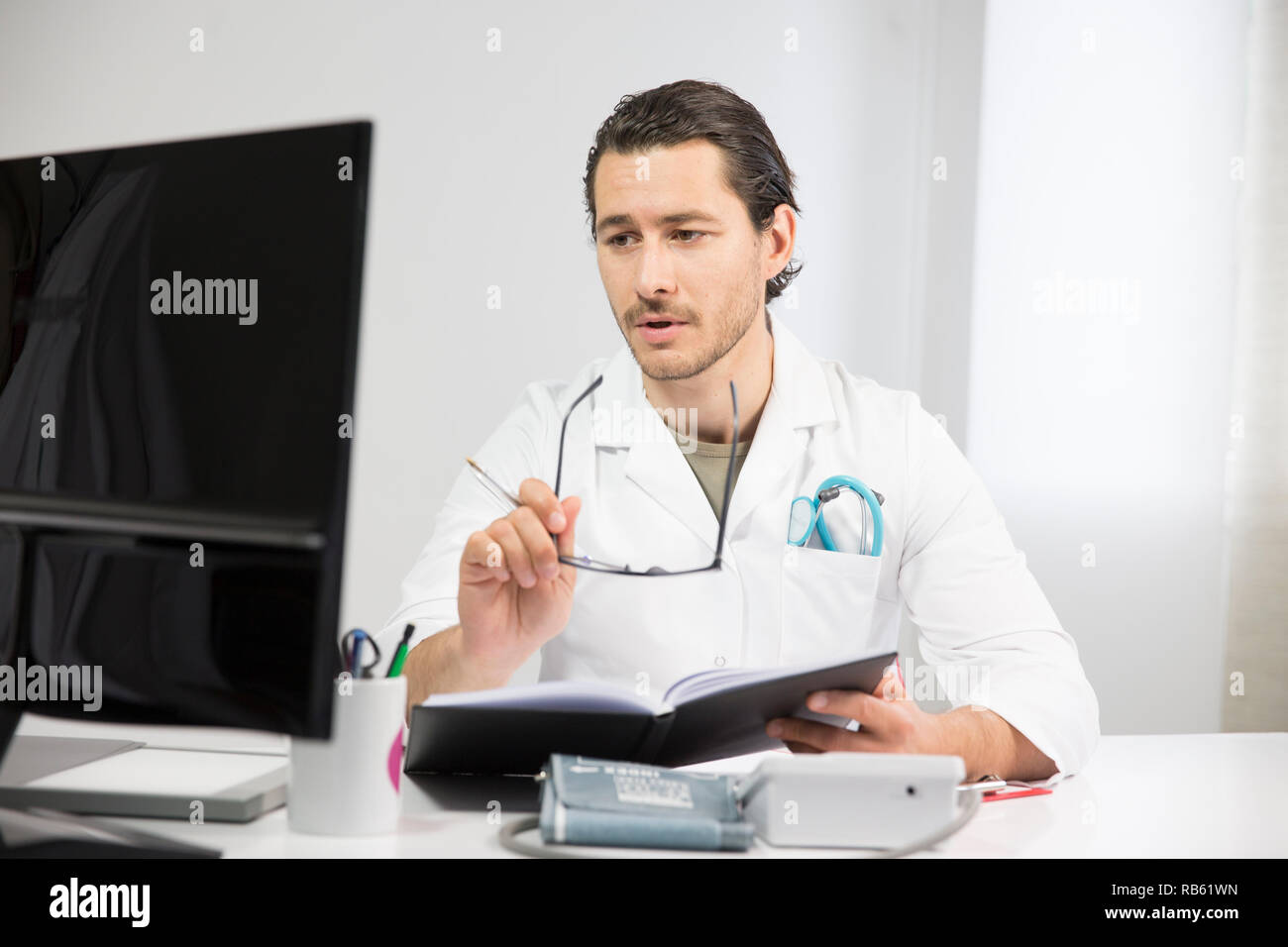 Doctor in front of laptop Stock Photo - Alamy