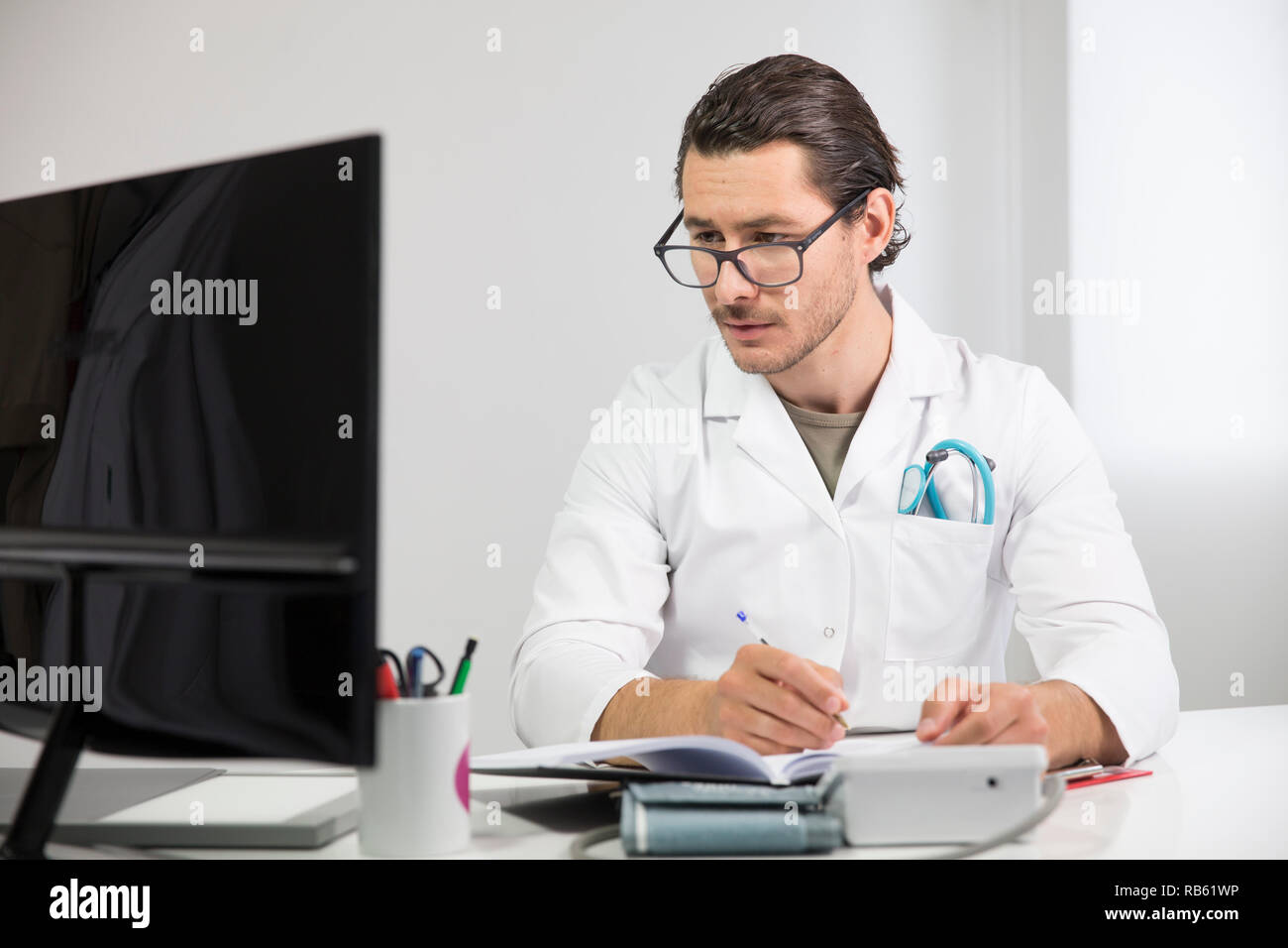 Doctor in front of laptop Stock Photo - Alamy