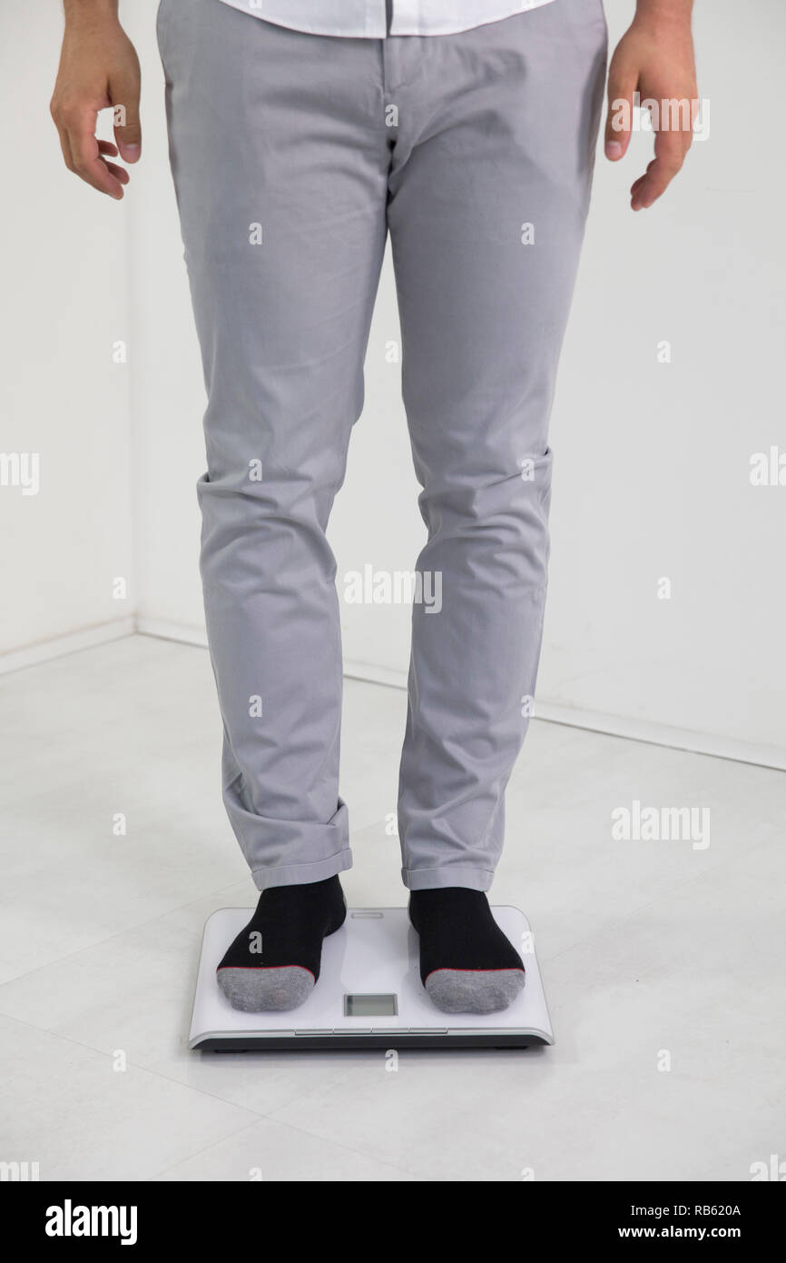 Man on weight scale Stock Photo - Alamy