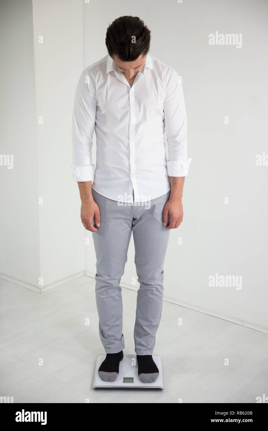 Man on weight scale Stock Photo - Alamy