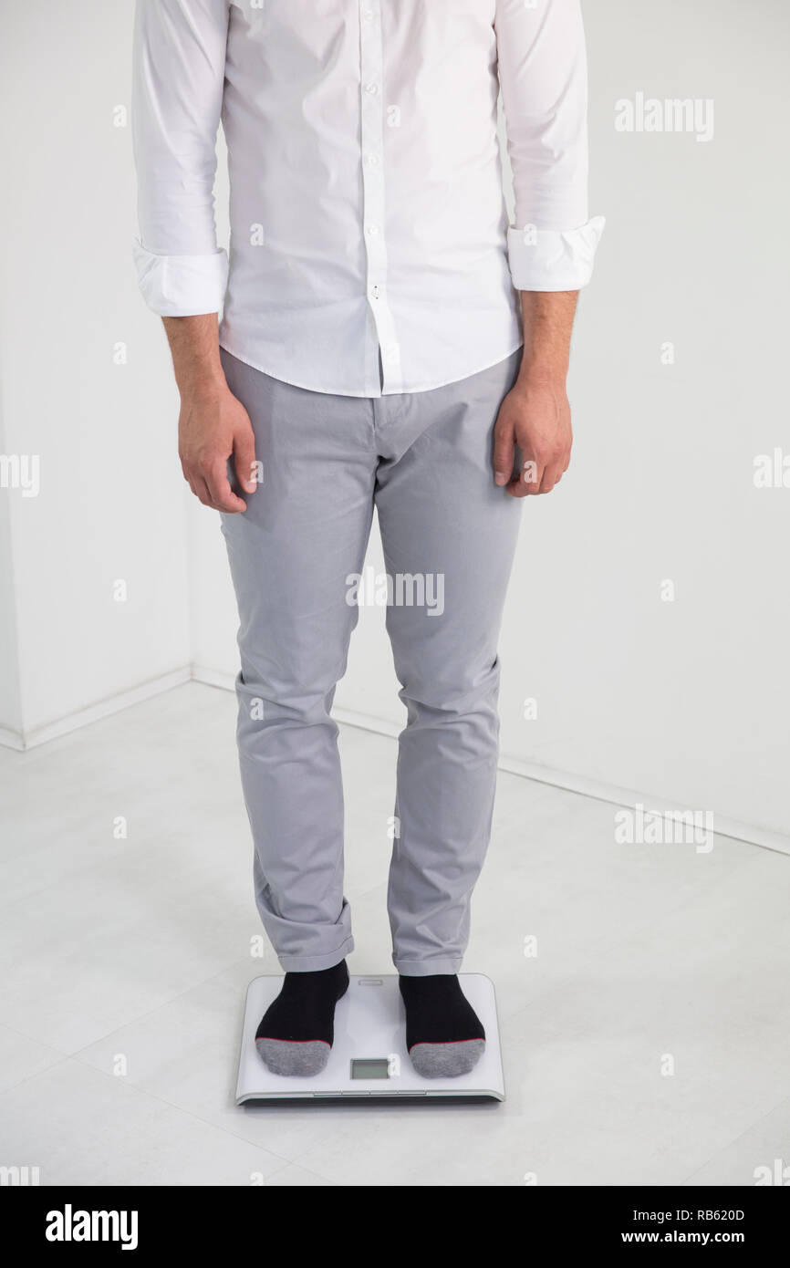 Man on weight scale Stock Photo - Alamy