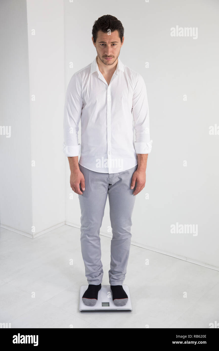 Man on weight scale Stock Photo - Alamy
