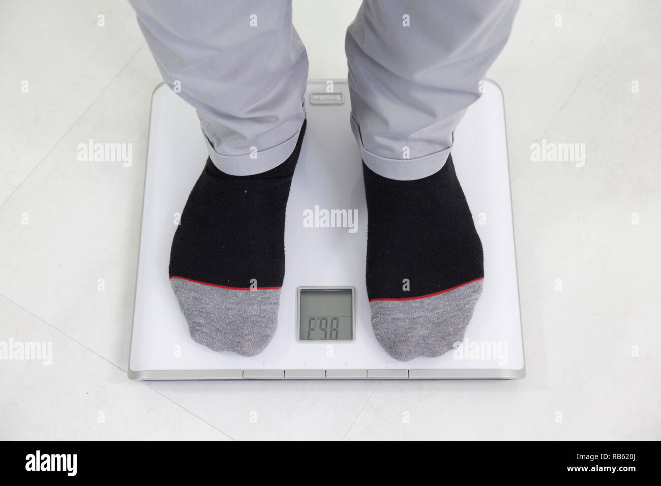 Man on weight scale Stock Photo - Alamy