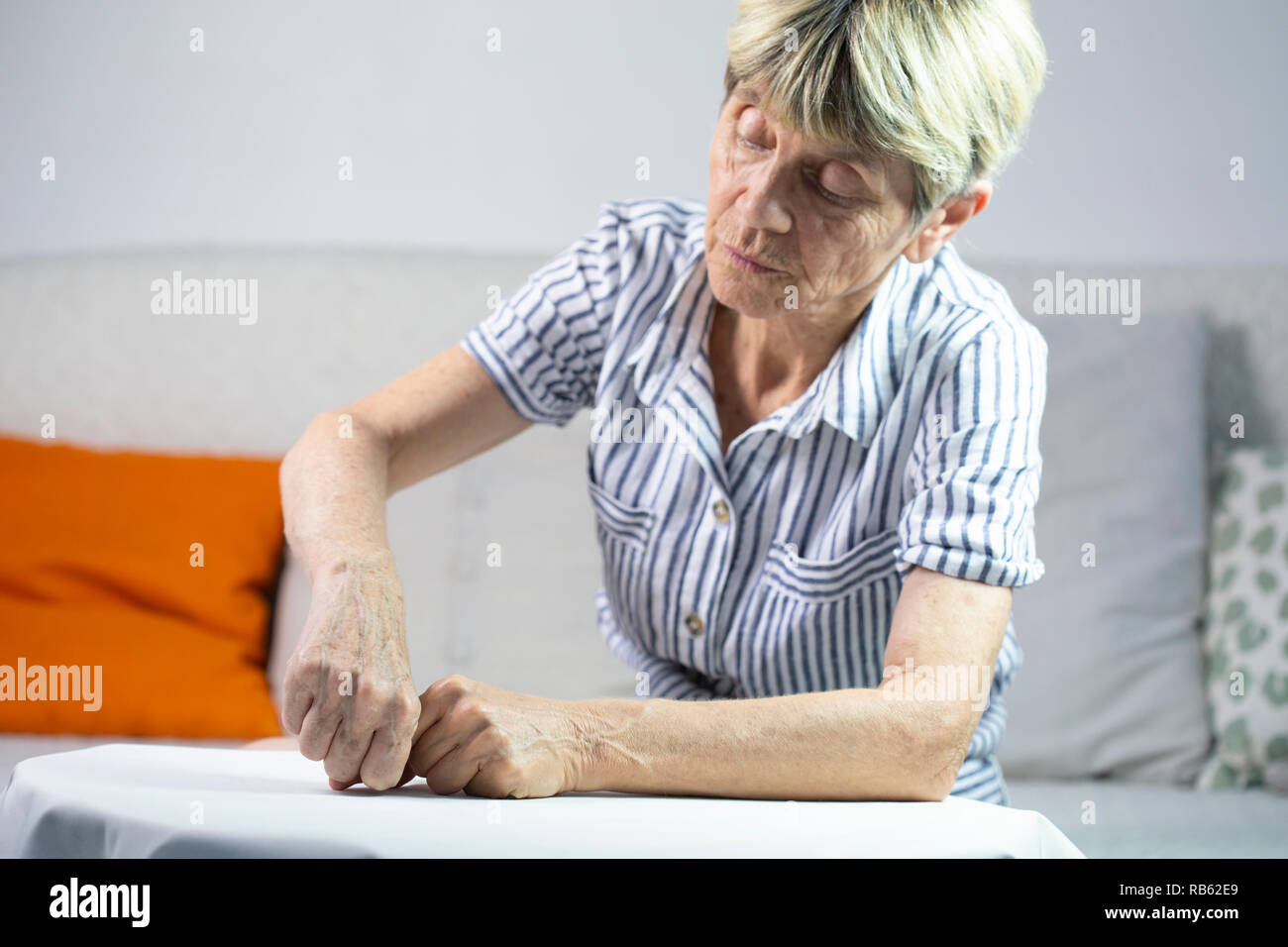 Old woman looking at his hands Stock Photo - Alamy