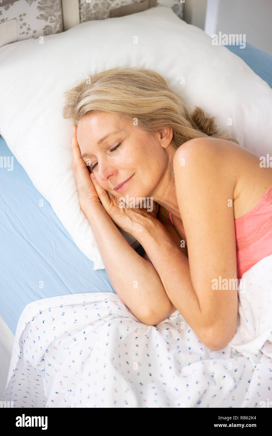 Woman sleeping in her bed Stock Photo - Alamy