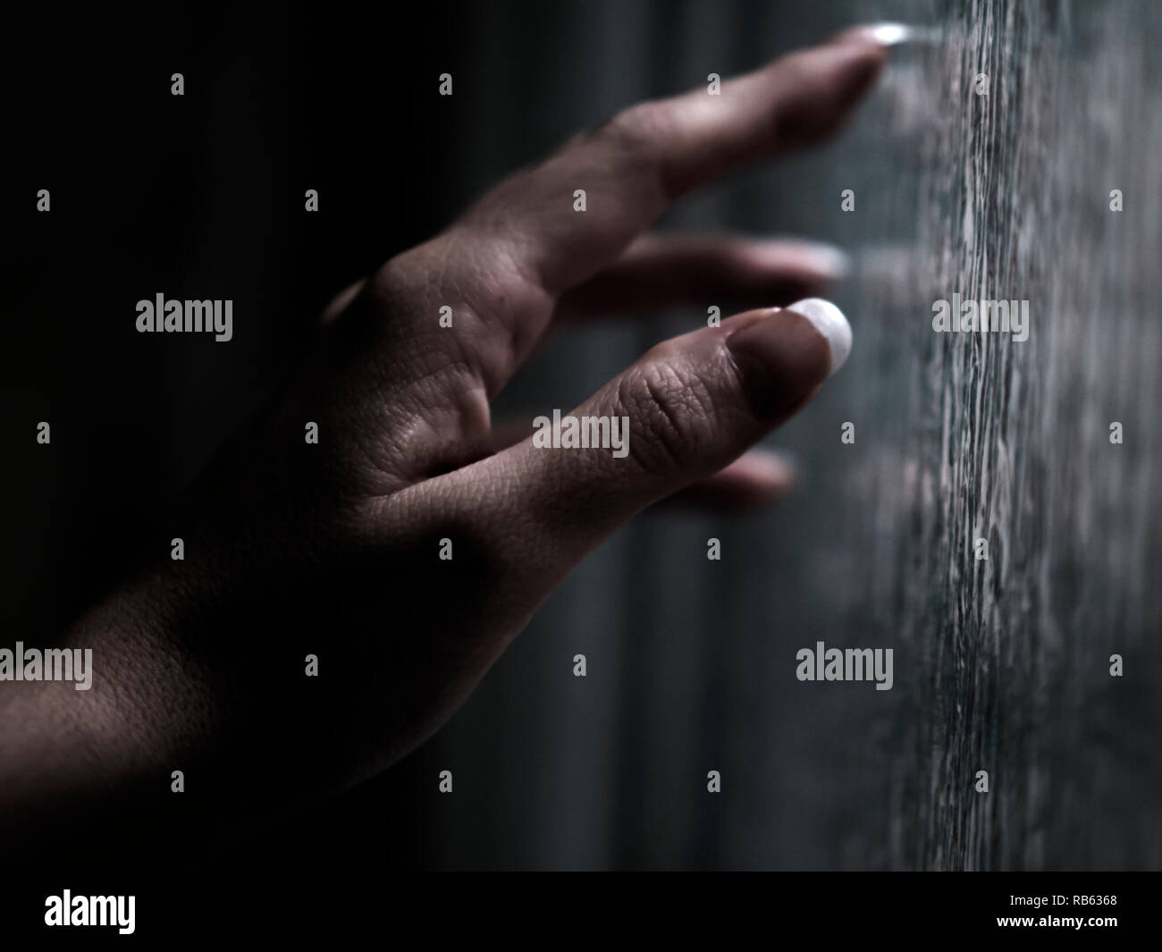 Woman lightly touching window glass Stock Photo - Alamy