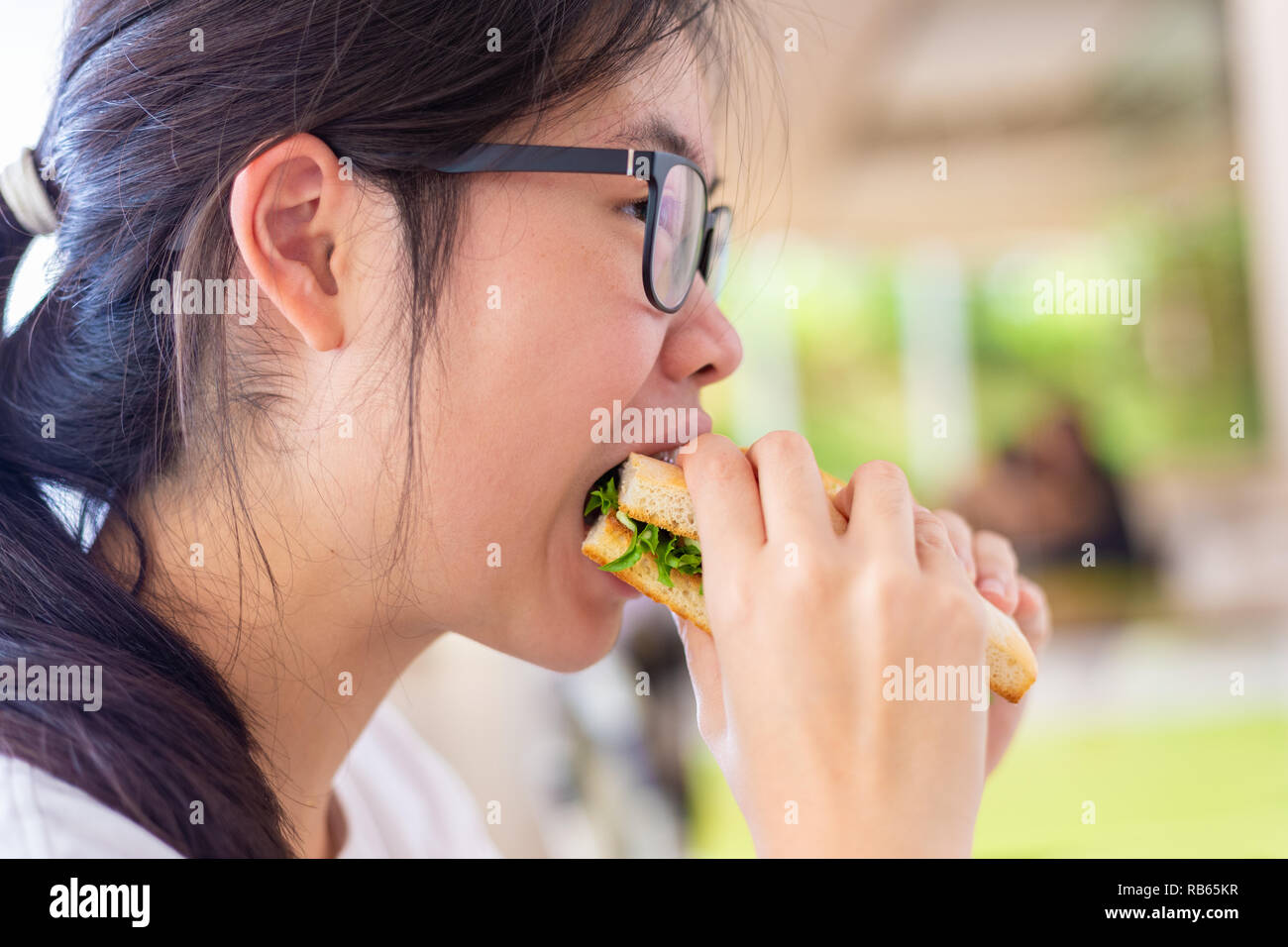 Asian woman eating sandwich hi-res stock photography and images - Alamy
