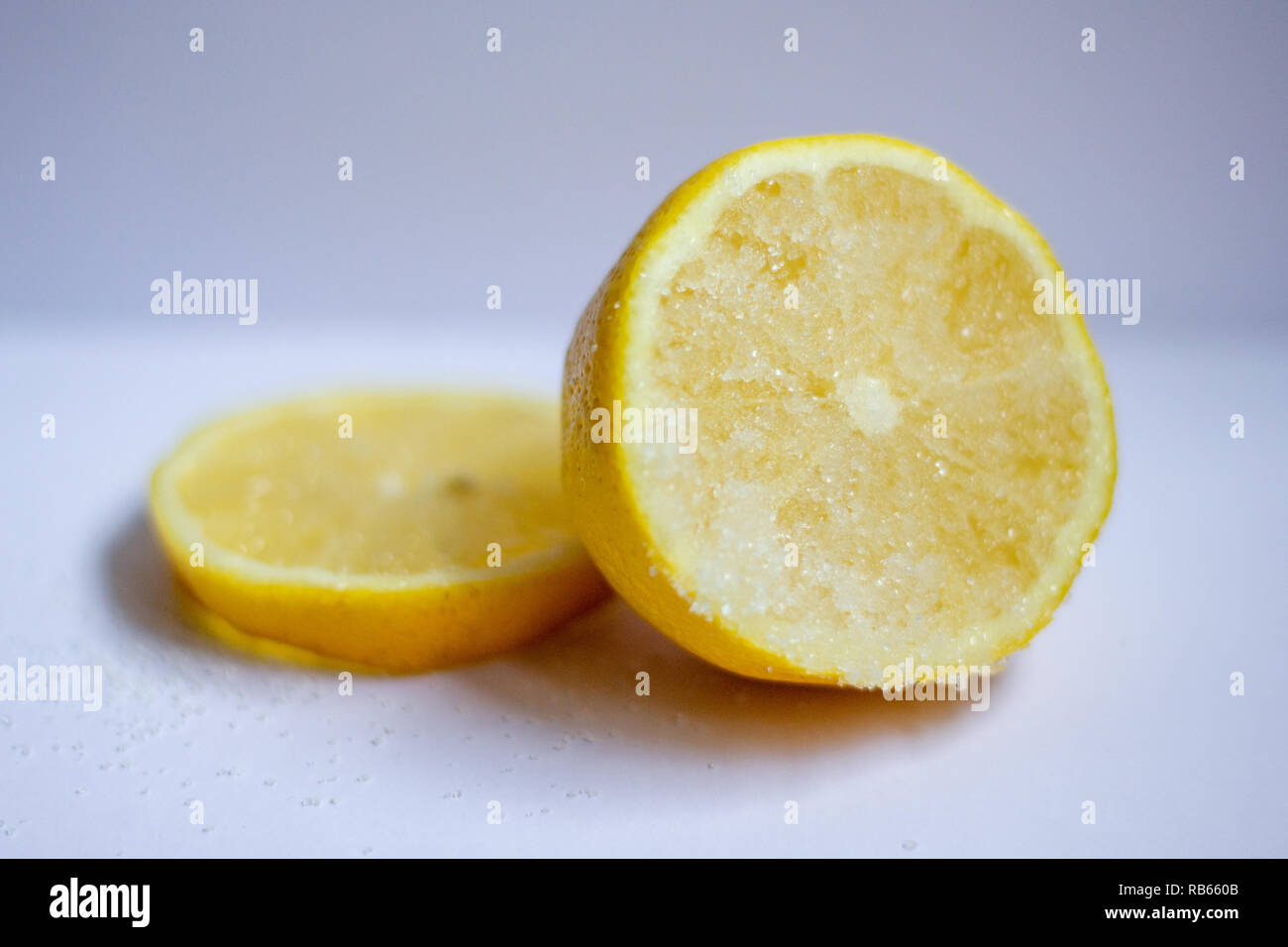 cut lemon with sugar on white background Stock Photo - Alamy