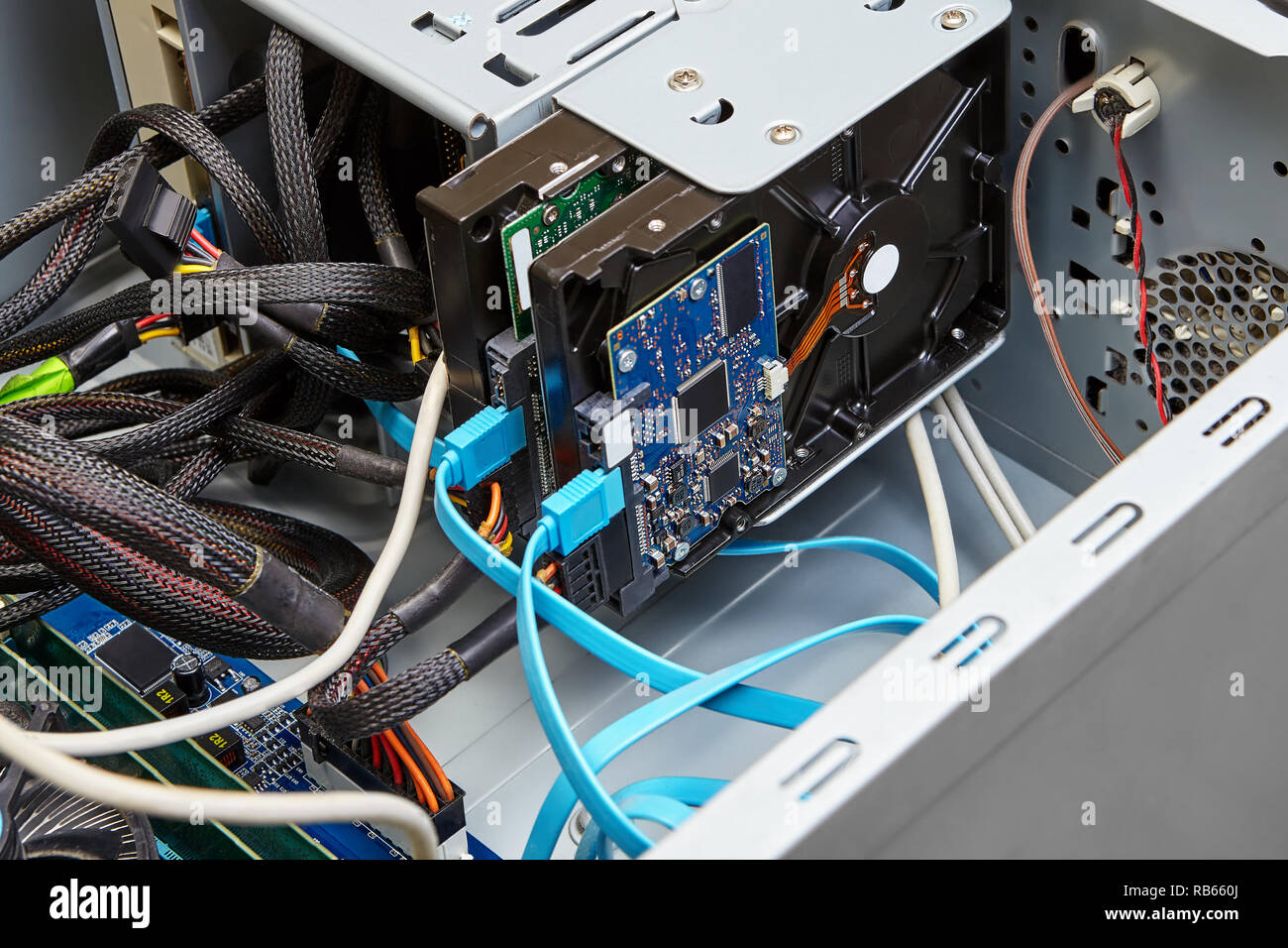 An unassembled computer system unit with HDD and blue SATA data cables ...