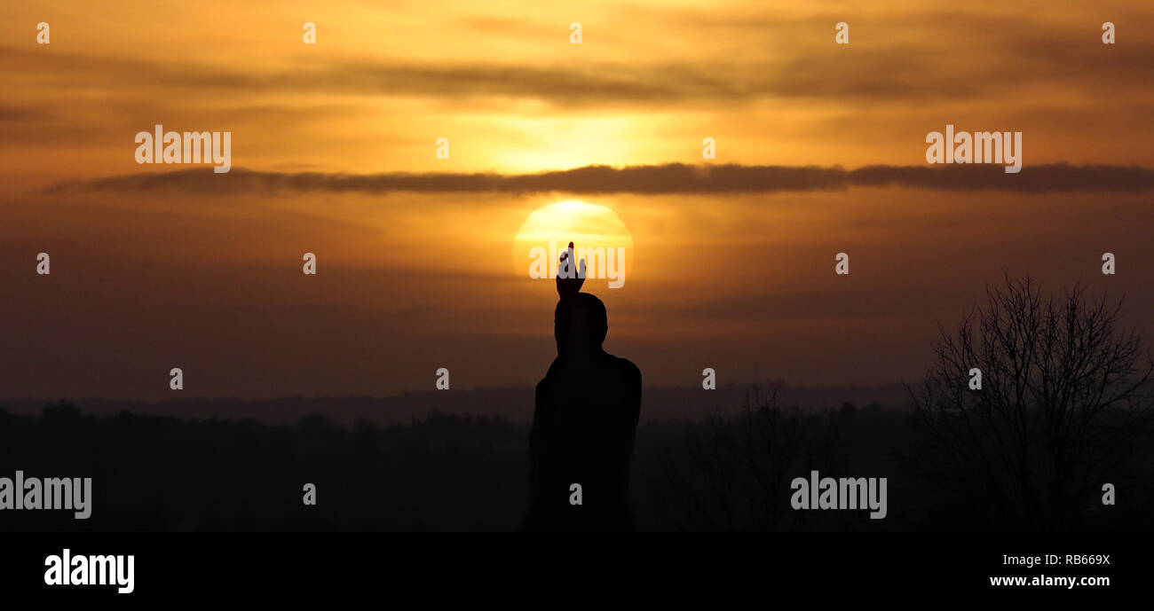 The sun sets in front of the Sir Edward Carson statue at Stormont in ...