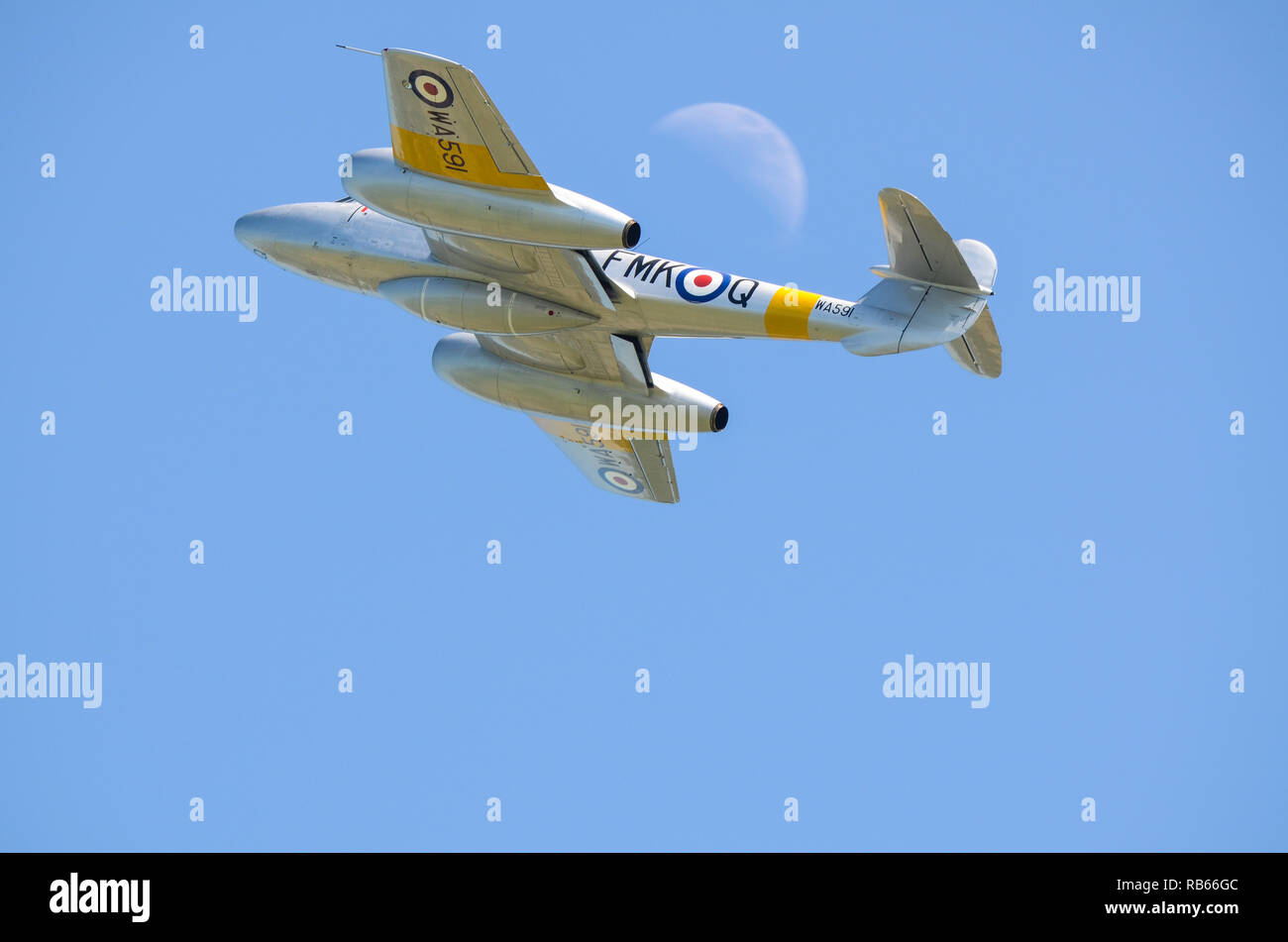 Gloster Meteor fighter jet plane flying past the moon in blue sky ...