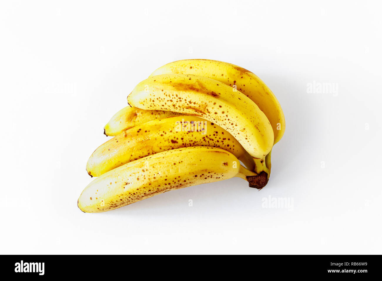 A bunch of five slightly overripe bananas isolated on a white ...