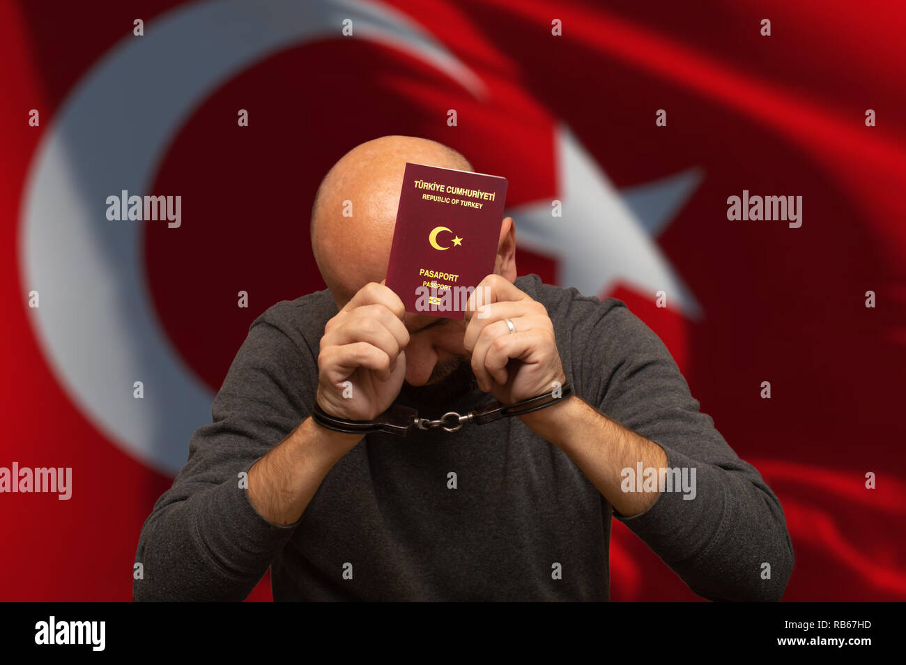 A detained Turkish citizen handcuffed with his passport in his hands ...