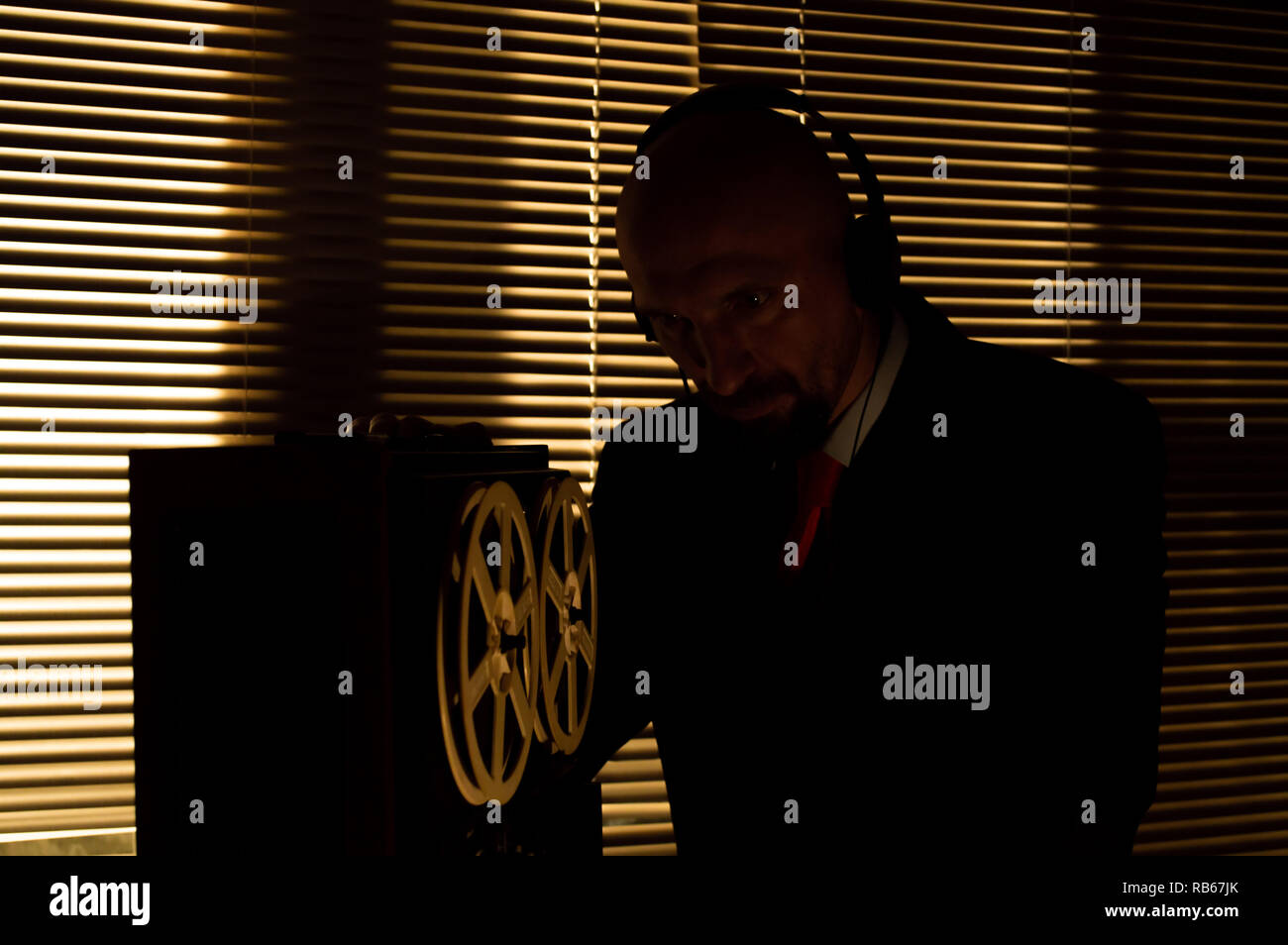 An FBI secret agent listens with headphones and records a conversation ...