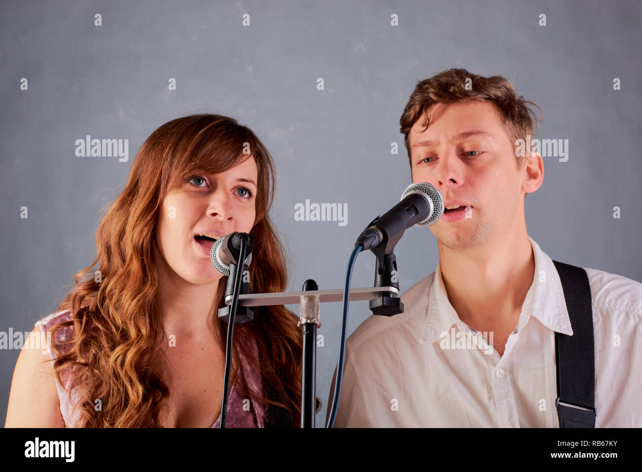 a guy and a girl stand and sing against Stock Photo - Alamy