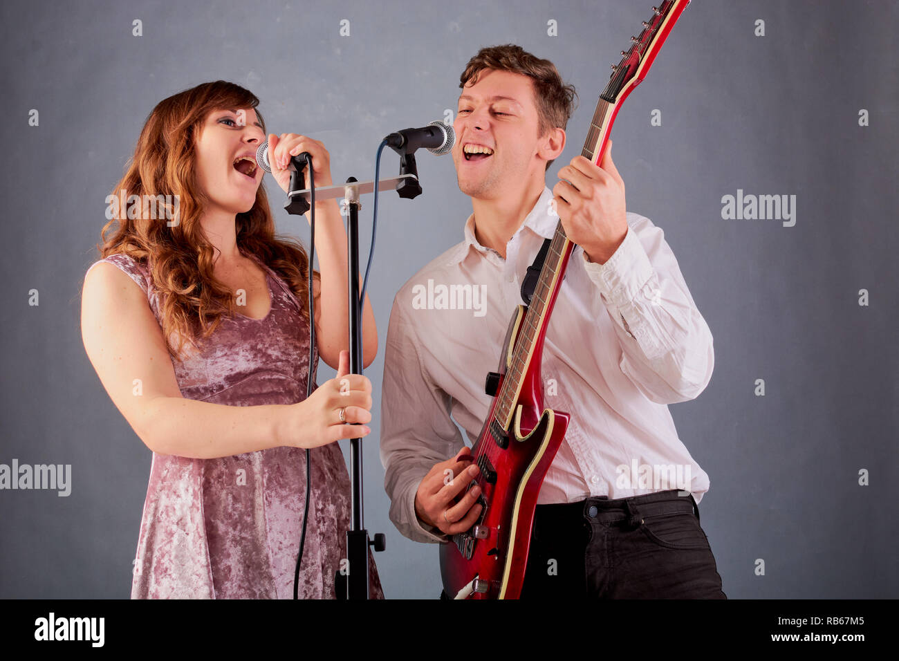 a guy and a girl stand and sing against Stock Photo - Alamy