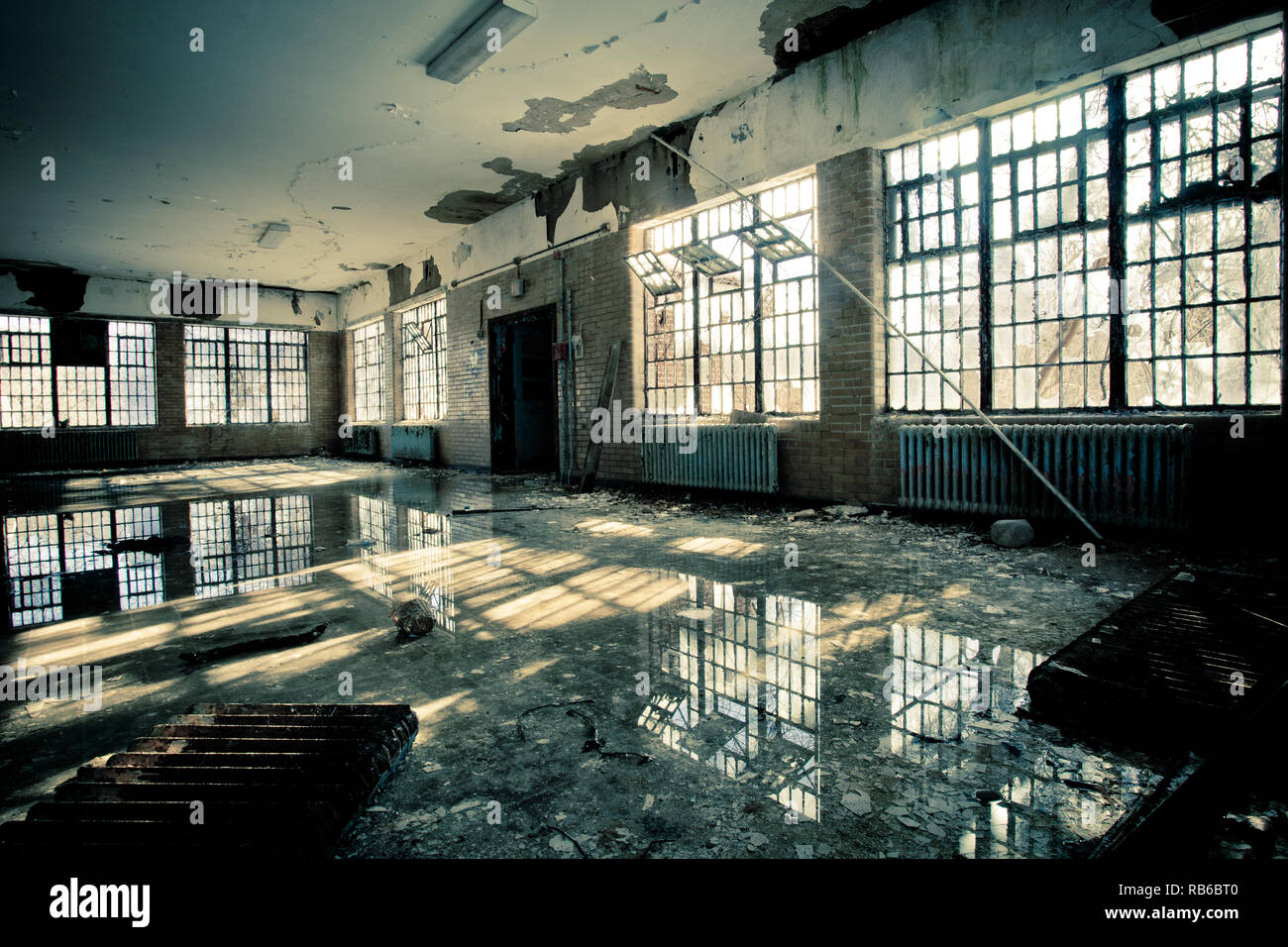 Interior of abandoned mental hospital with broken windows and water ...