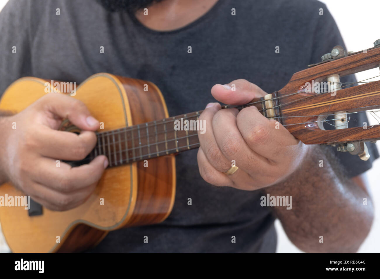 Young man playing Cavaquinho with shirt and black pants on white ...